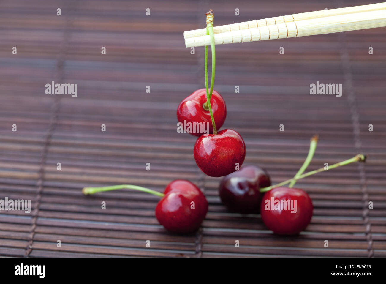 cherry and chopsticks on bamboo mat Stock Photo - Alamy