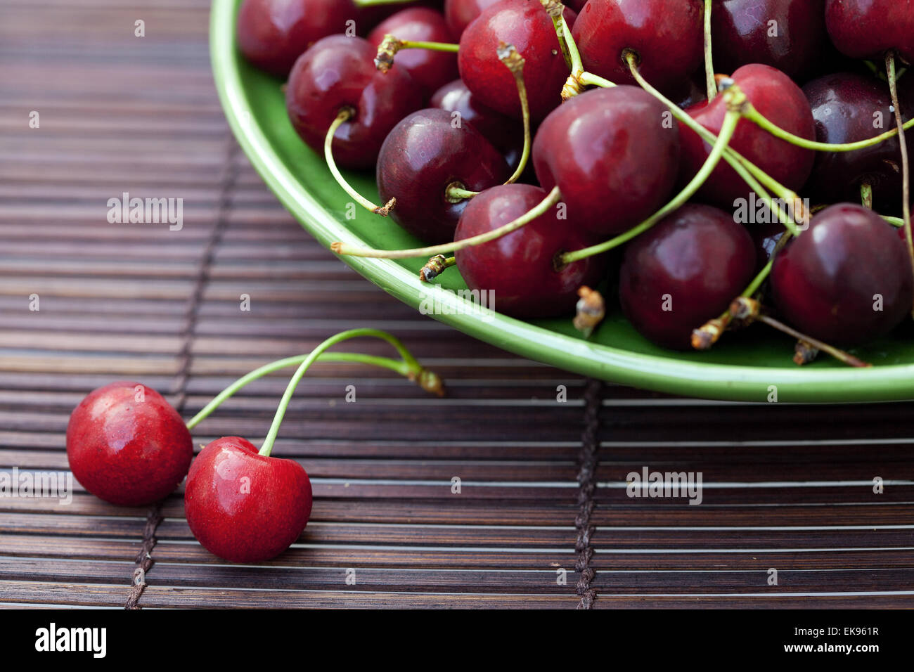 cherry in plate on a bamboo mat Stock Photo - Alamy