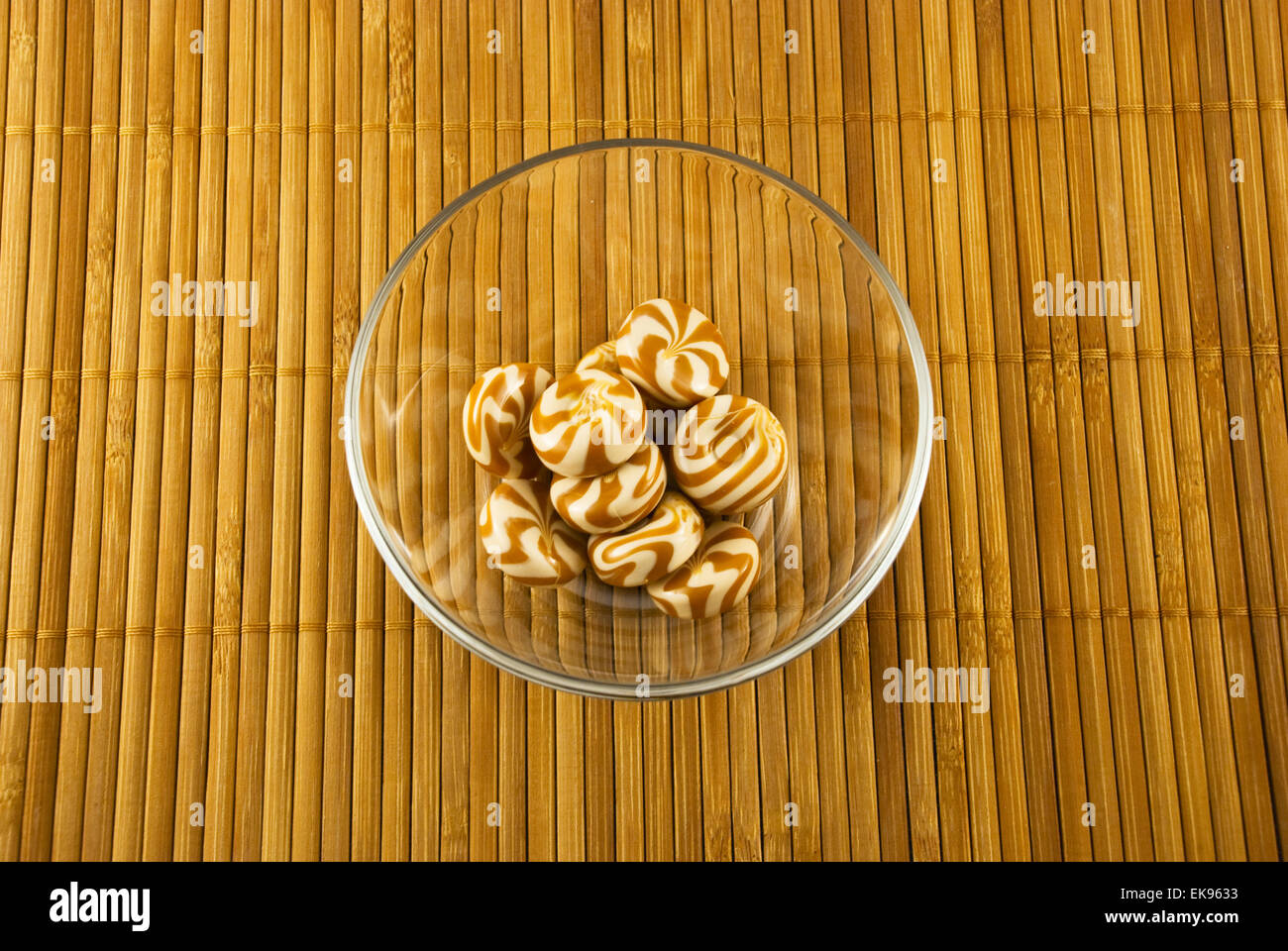 Candy in a glass bowl on a bamboo mat Stock Photo - Alamy