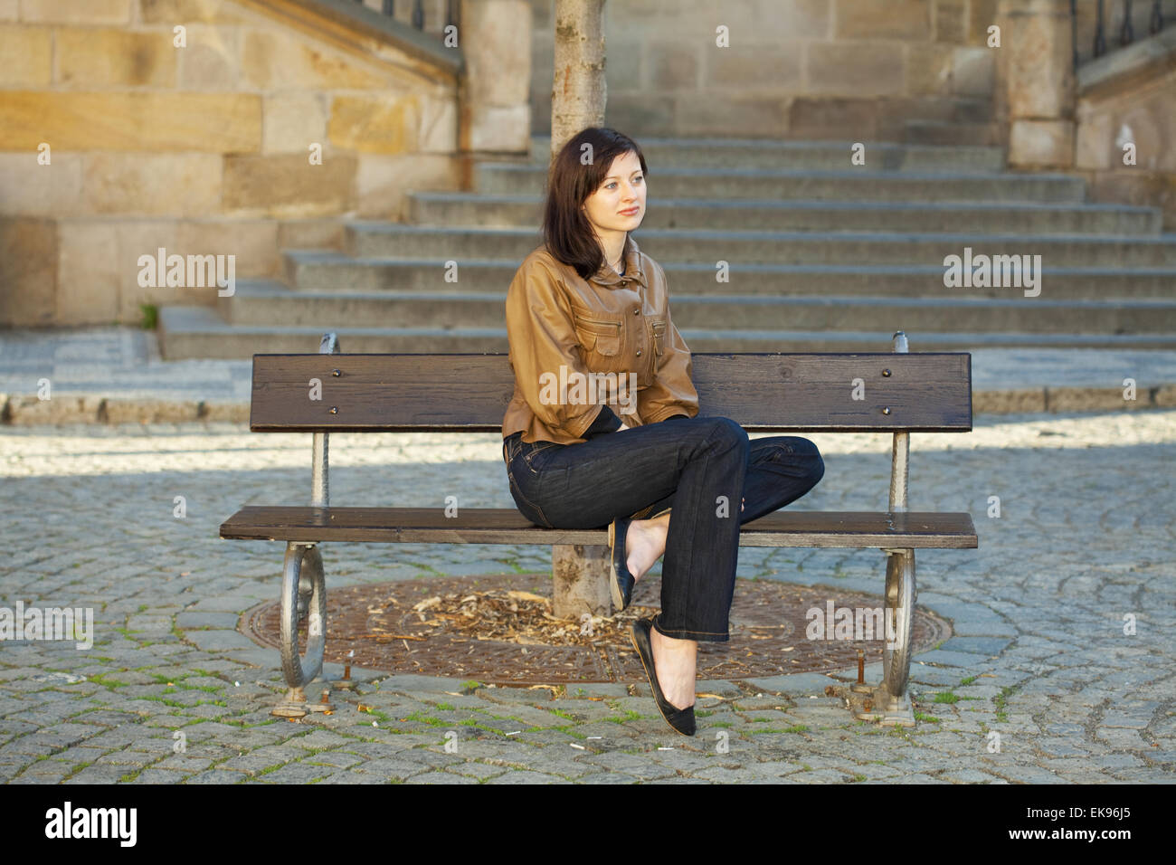 beautiful young woman sitting on a bench Stock Photo - Alamy