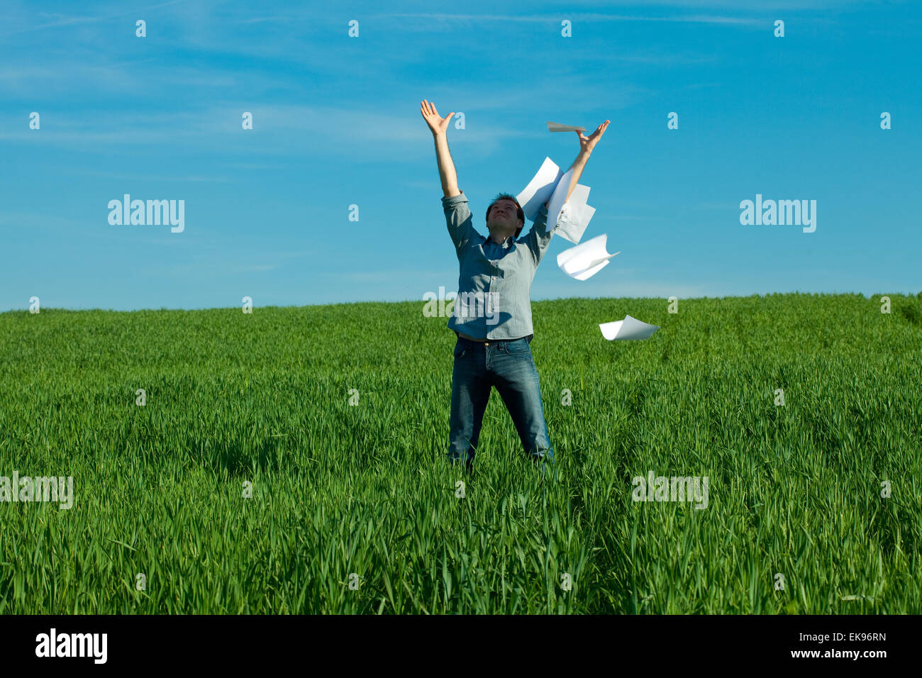 young man throwing a paper in the green field Stock Photo - Alamy