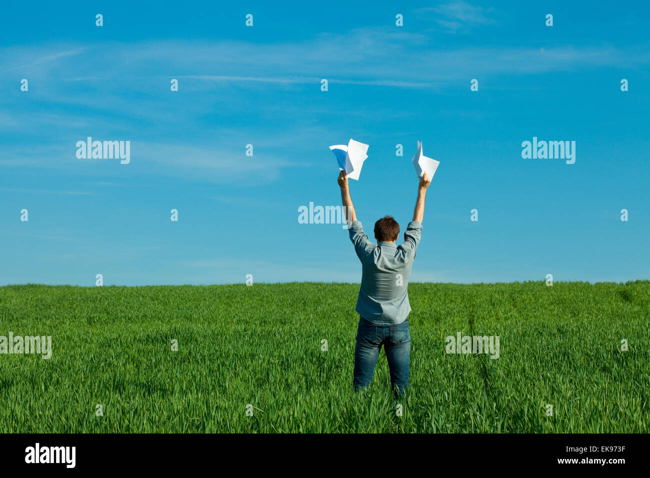 young man throwing a paper in the green field Stock Photo - Alamy