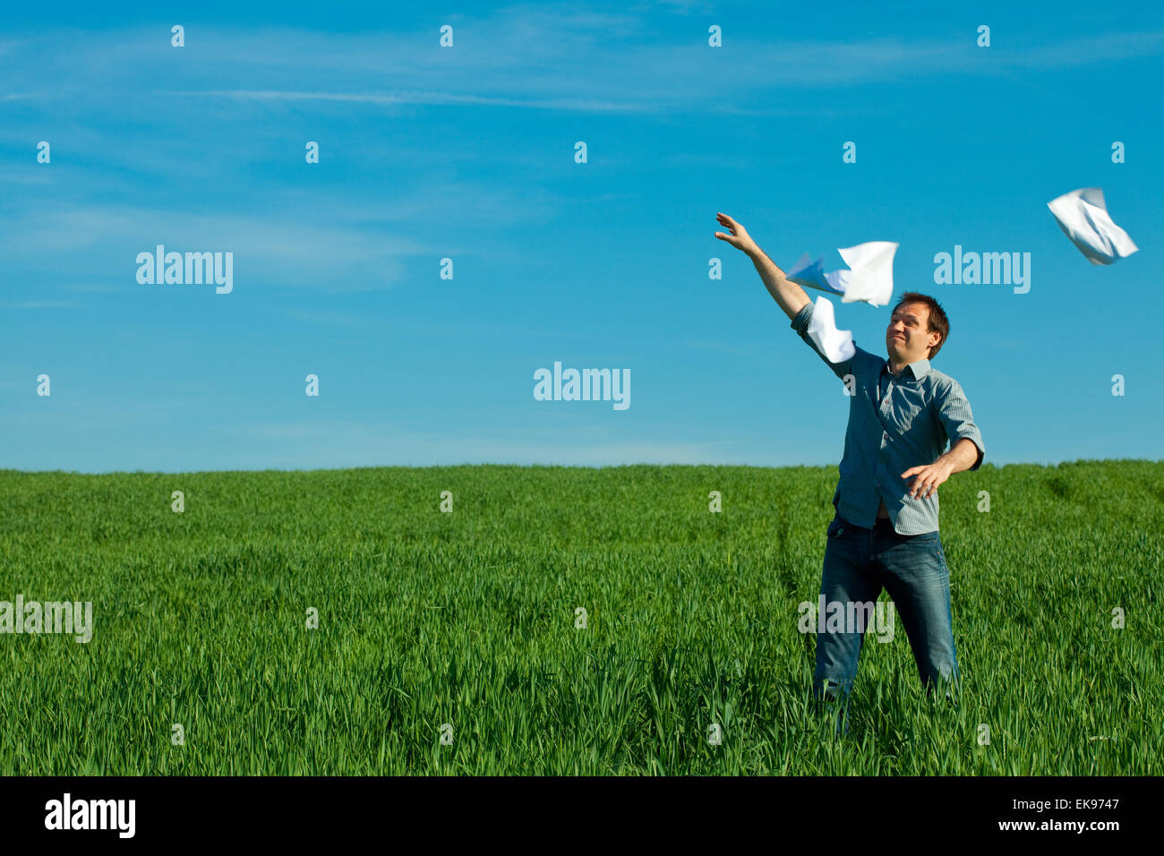 young man throwing a paper in the green field Stock Photo - Alamy