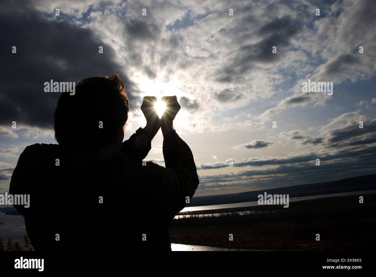 man holding a sun in his hands against the sky Stock Photo - Alamy