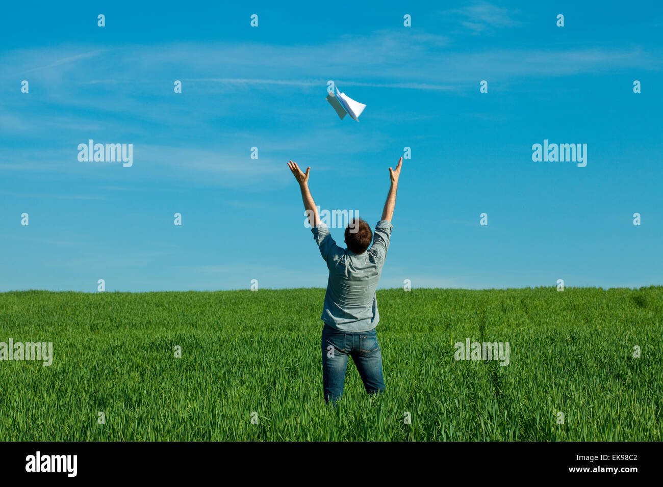 young man throwing a paper in the green field Stock Photo - Alamy