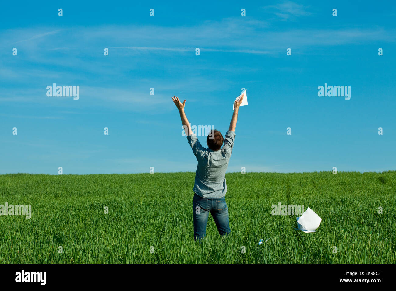 young man throwing a paper in the green field Stock Photo - Alamy