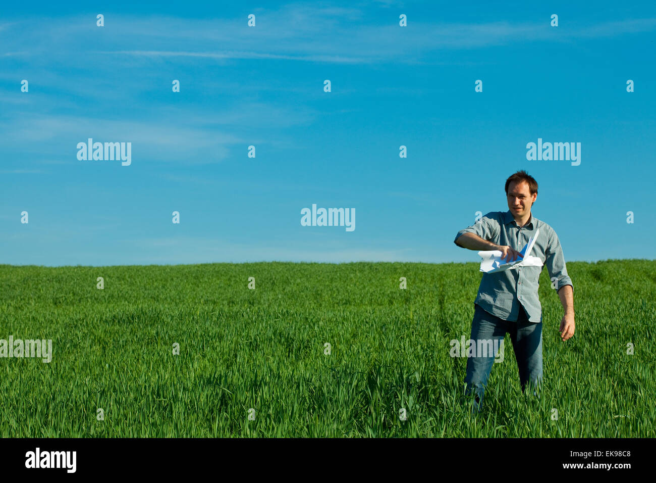 young man throwing a paper in the green field Stock Photo - Alamy