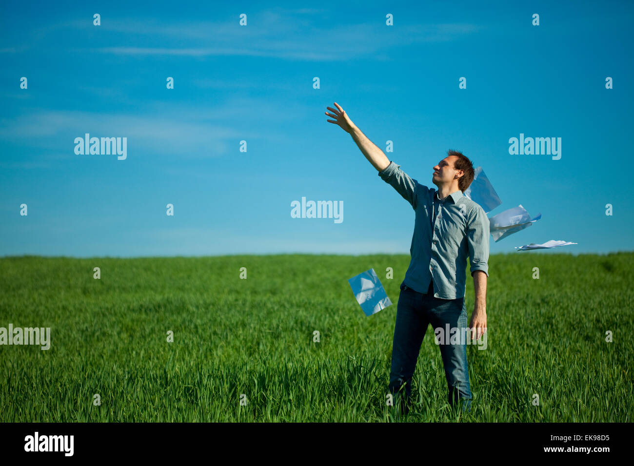 young man throwing a paper in the green field Stock Photo - Alamy