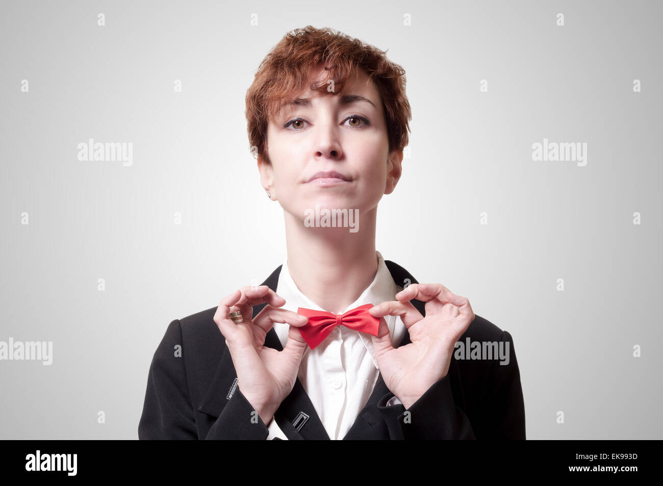 elegant businesswoman adjusting bow tie Stock Photo - Alamy