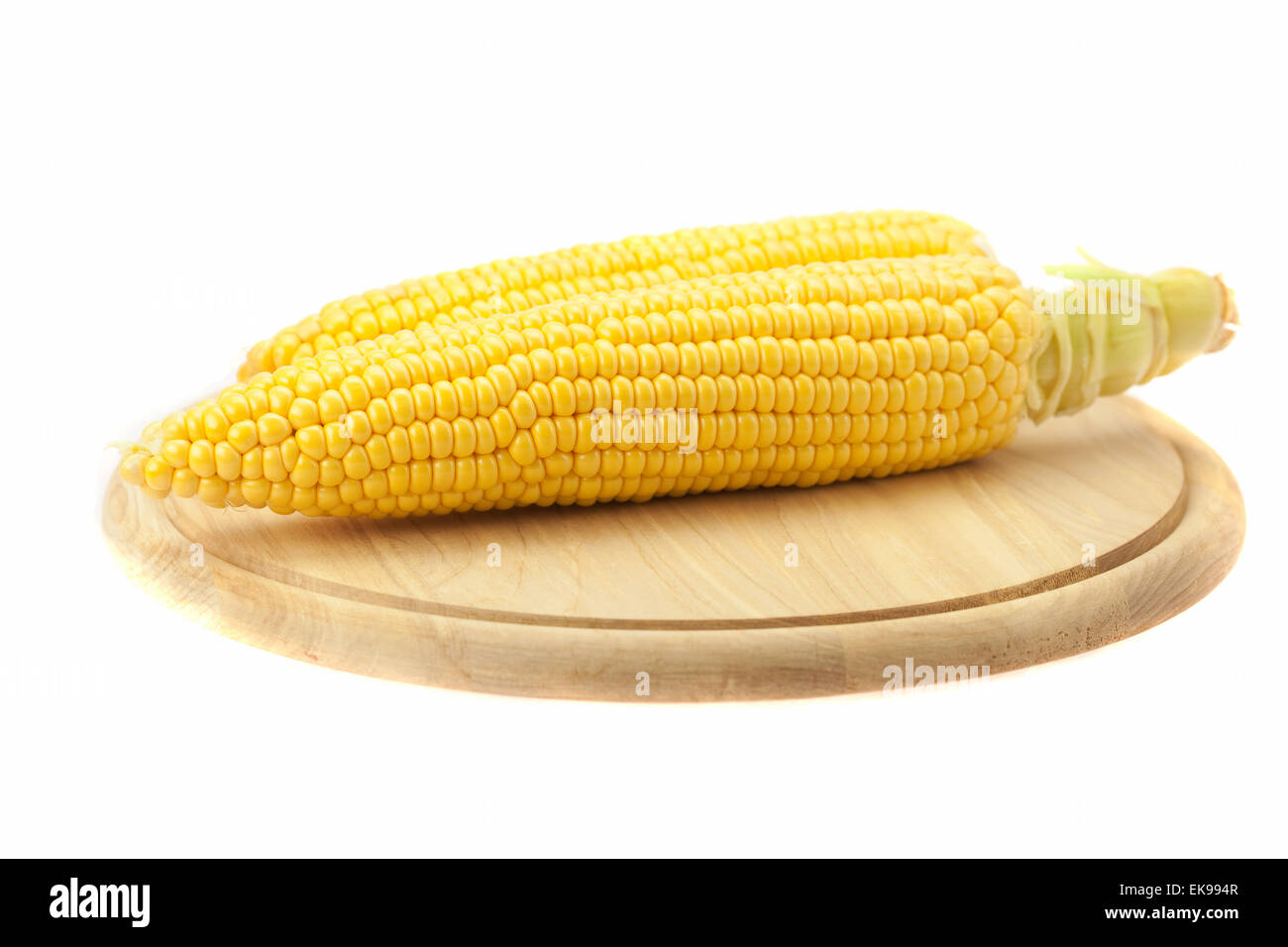 Corn lying on a cutting board isolated on white Stock Photo - Alamy