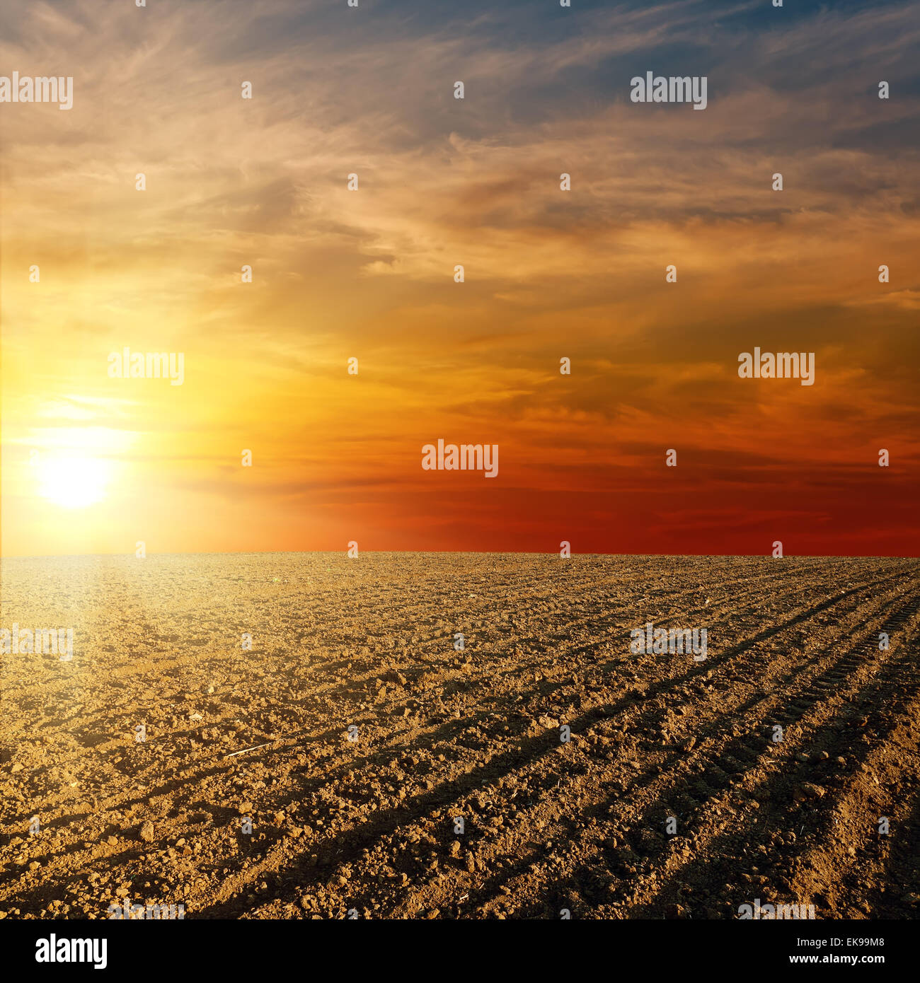 red sunset over ploughed farm field Stock Photo - Alamy
