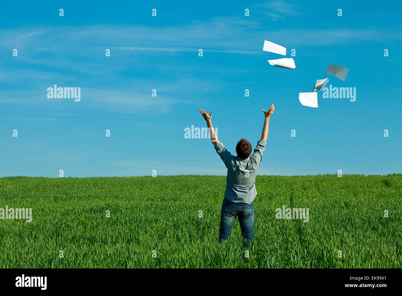 young man throwing a paper in the green field Stock Photo - Alamy