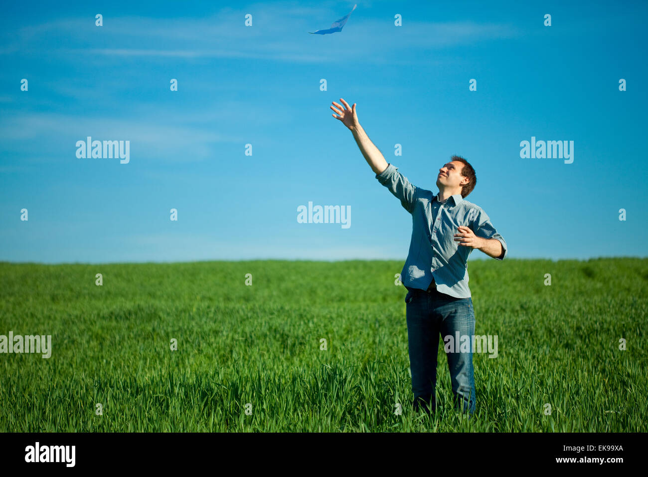 young man throwing a paper in the green field Stock Photo - Alamy