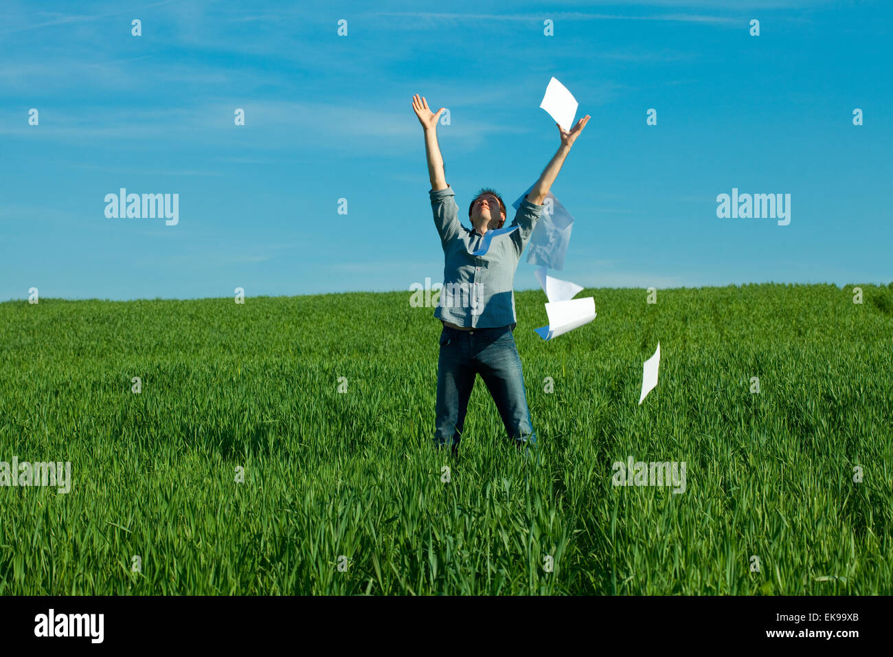 young man throwing a paper in the green field Stock Photo - Alamy