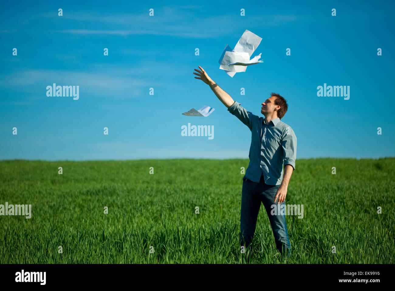 young man throwing a paper in the green field Stock Photo - Alamy