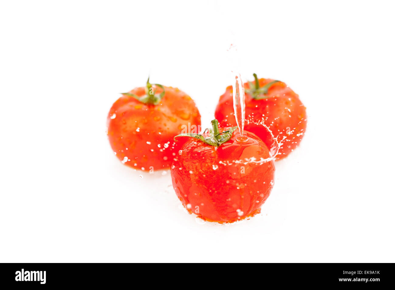 tomatoes under running water isolated on white Stock Photo - Alamy