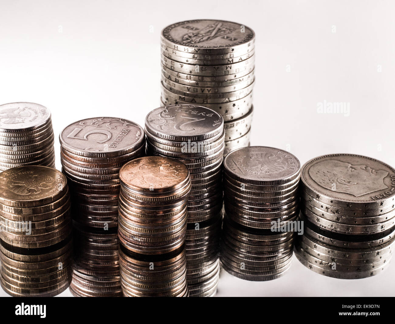 stack of old shiny coins on a brilliant background with reflection ...