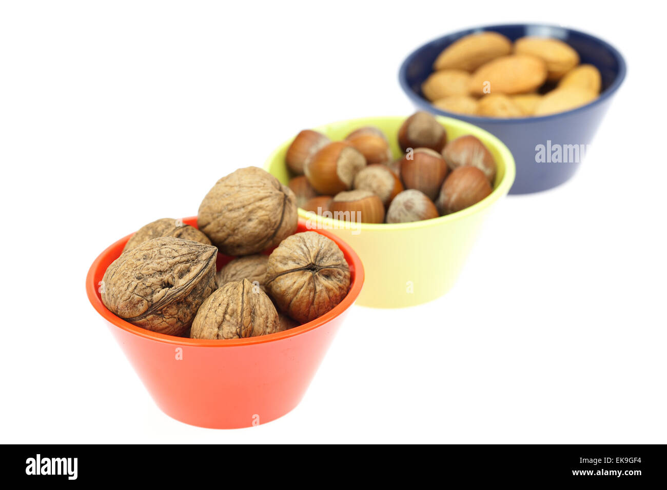 nuts in bowls isolated on white Stock Photo - Alamy