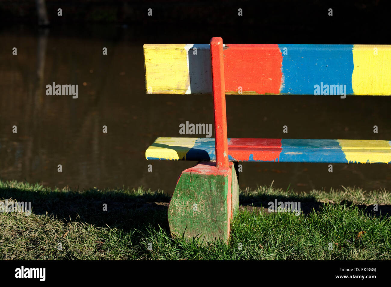 multi-colored bench standing in a park near the pond Stock Photo - Alamy