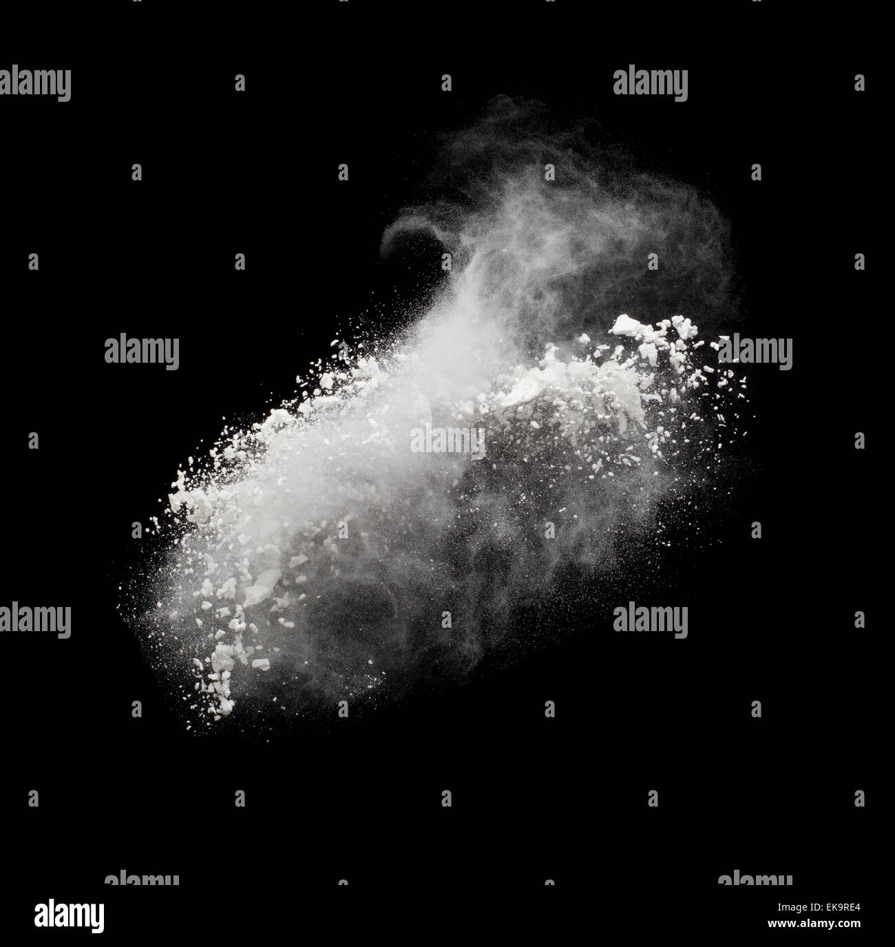 Freeze motion of white powder exploding, isolated on black. Abstract ...