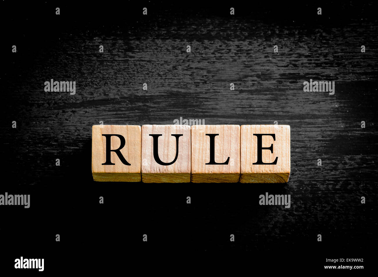 Word RULE. Wooden small cubes with letters isolated on black background ...