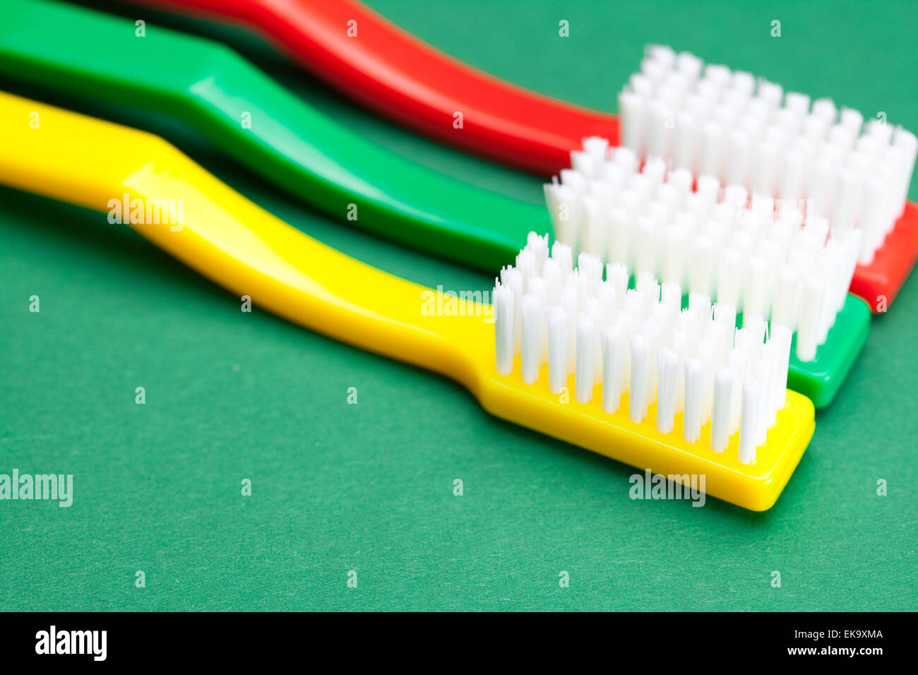 colored toothbrush on a green background Stock Photo - Alamy