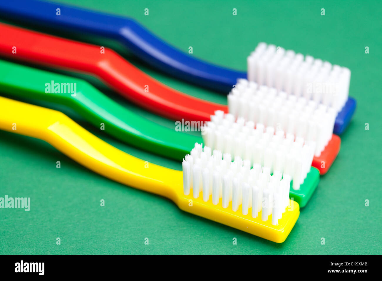 colored toothbrush on a green background Stock Photo - Alamy