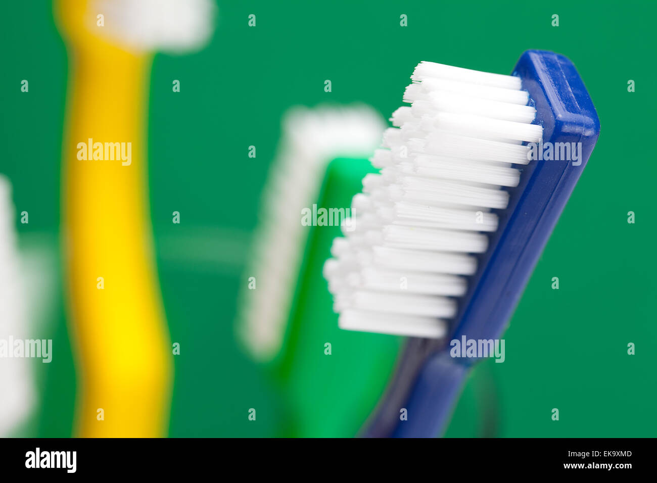 colored toothbrush in a glass on a green background Stock Photo - Alamy
