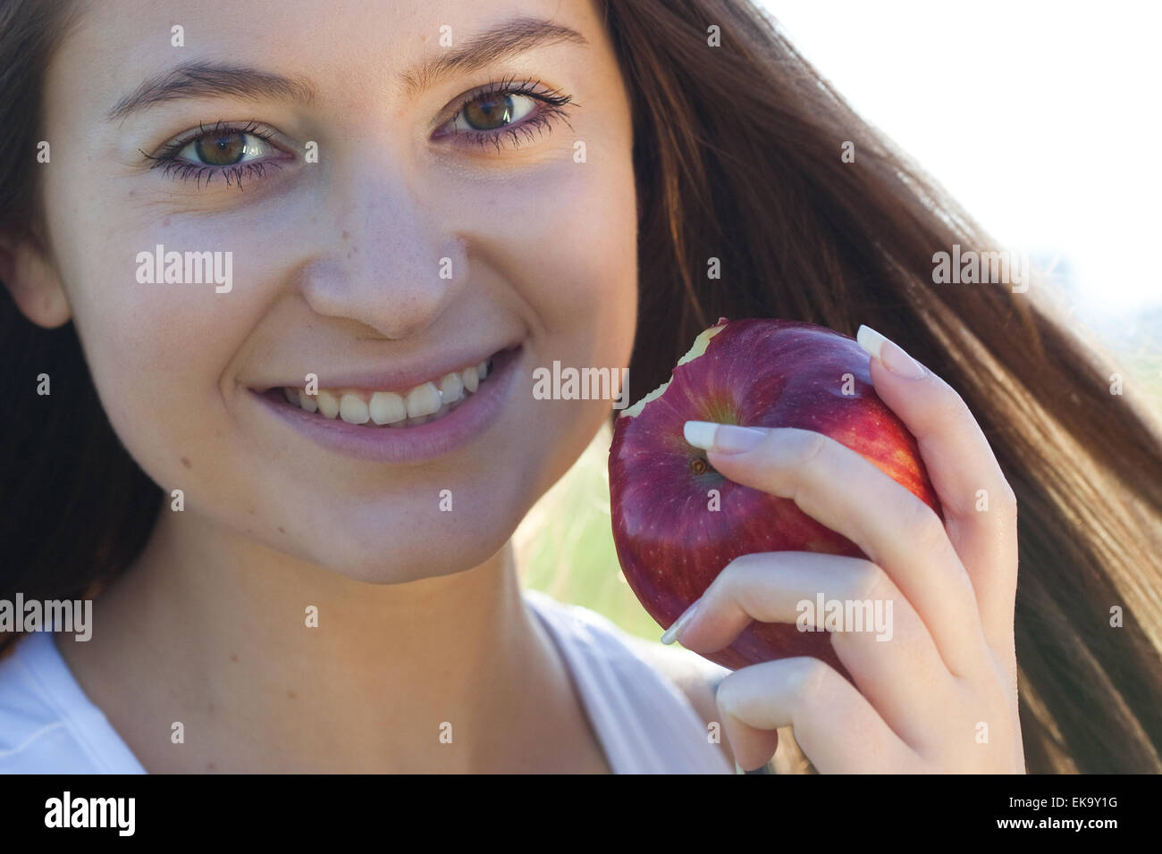 portrait of a beautiful young woman with apple outdoor Stock Photo - Alamy