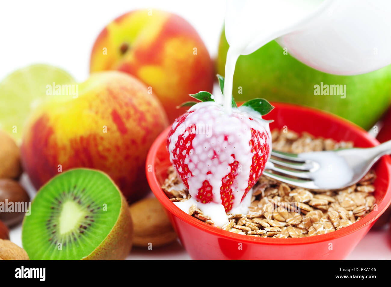 strawberry, peach, apple, kiwi, fork, milk and flakes in a bowl Stock ...