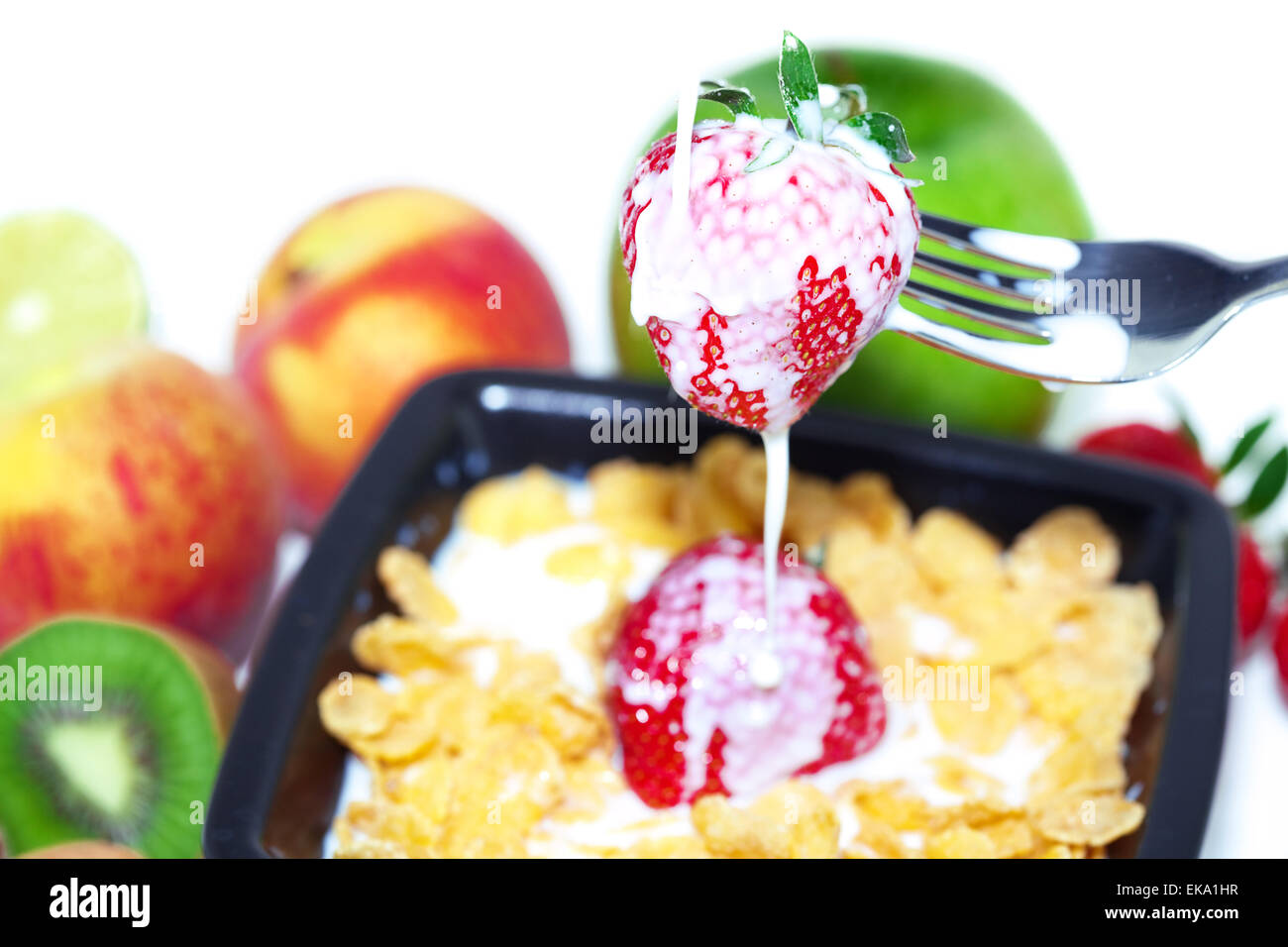 strawberry, peach, apple, kiwi, fork, milk and flakes in a bowl Stock ...