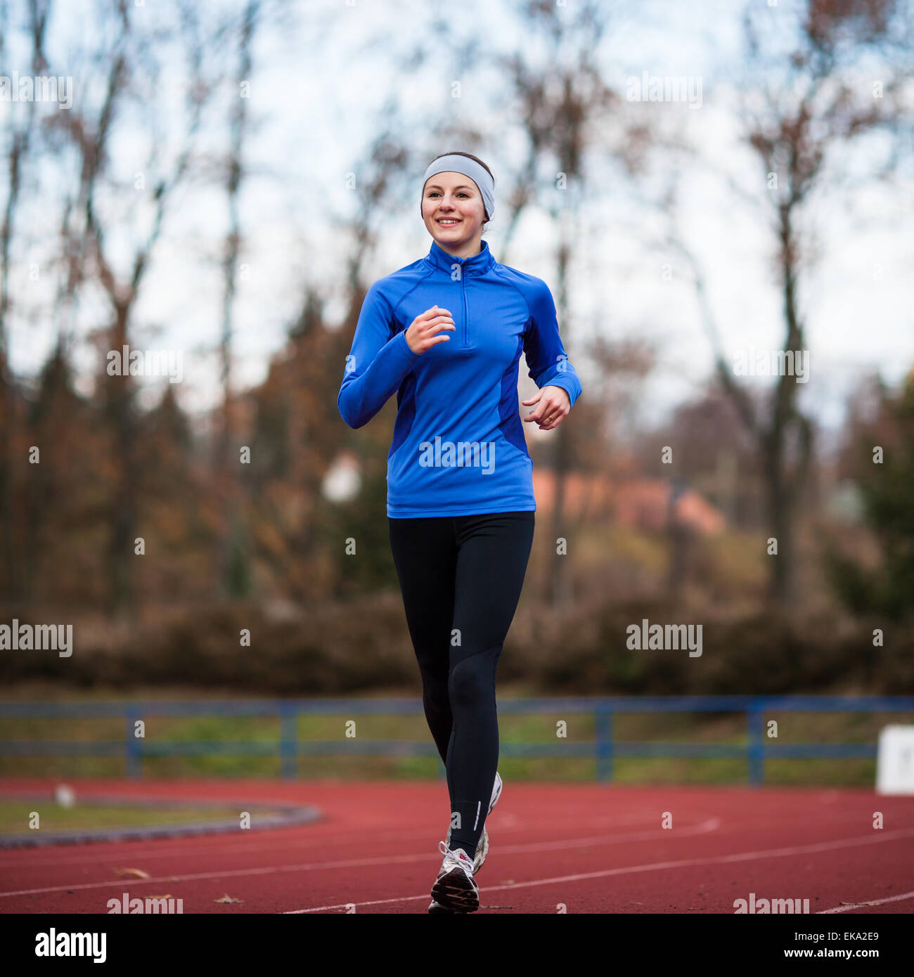 Young woman running at a track and field stadium Stock Photo - Alamy