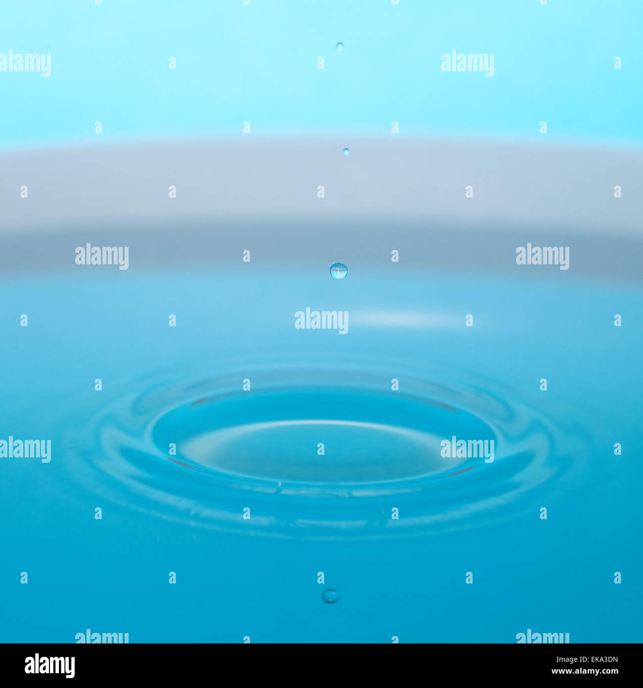 water drop and splash on a blue background Stock Photo - Alamy