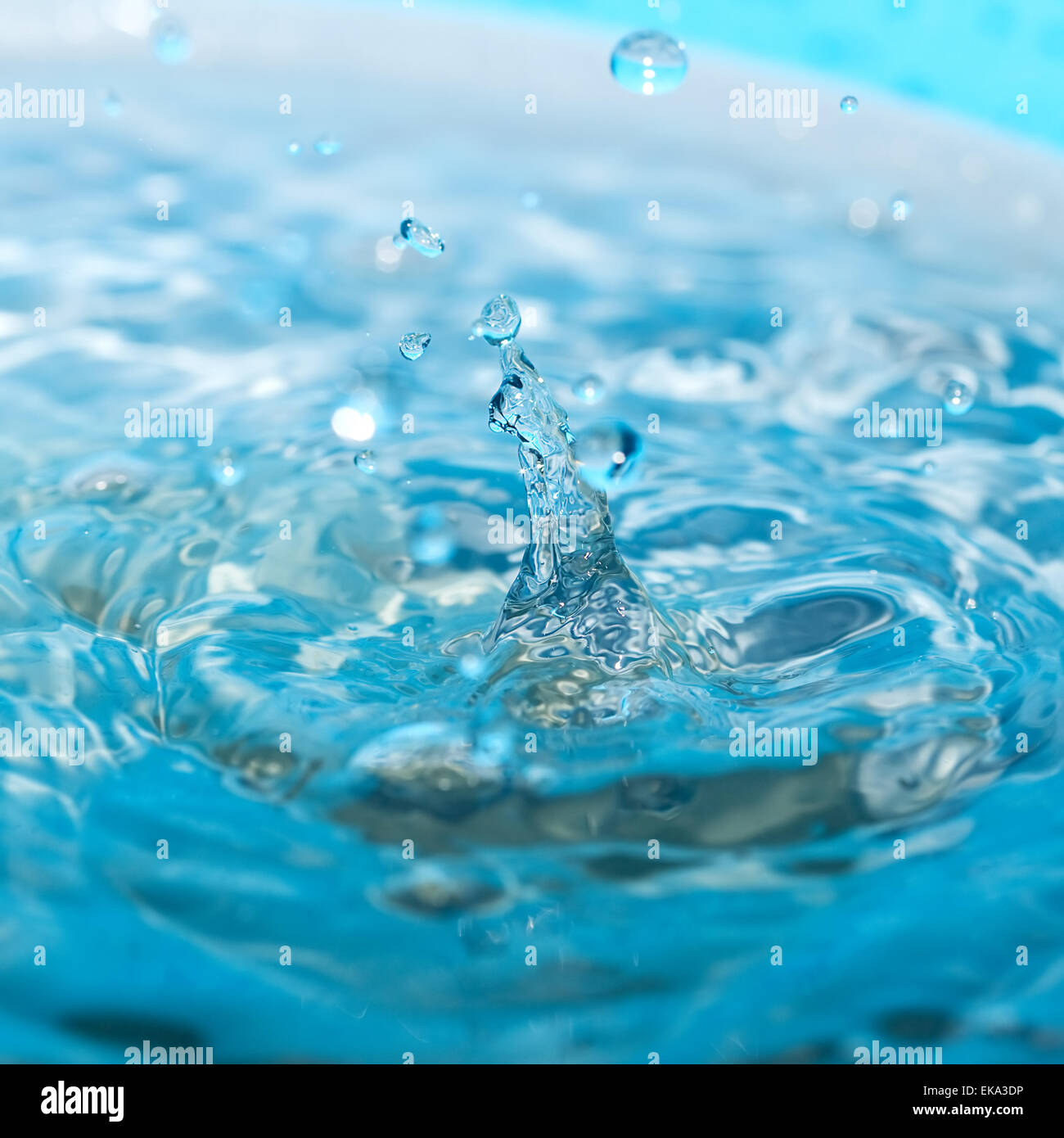 water drop and splash on a blue background Stock Photo - Alamy