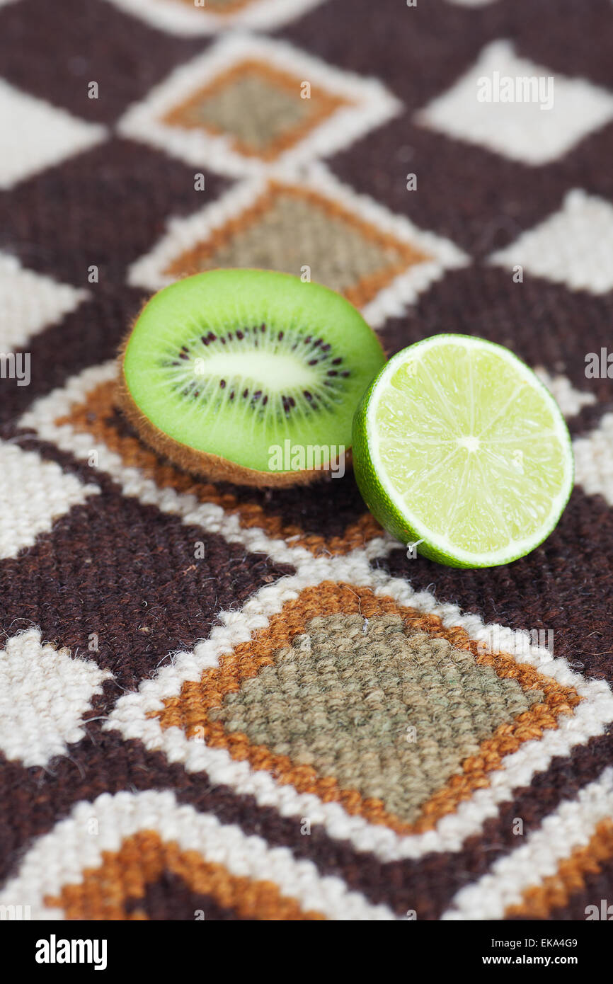 kiwi and lime on ethnic mat Stock Photo - Alamy