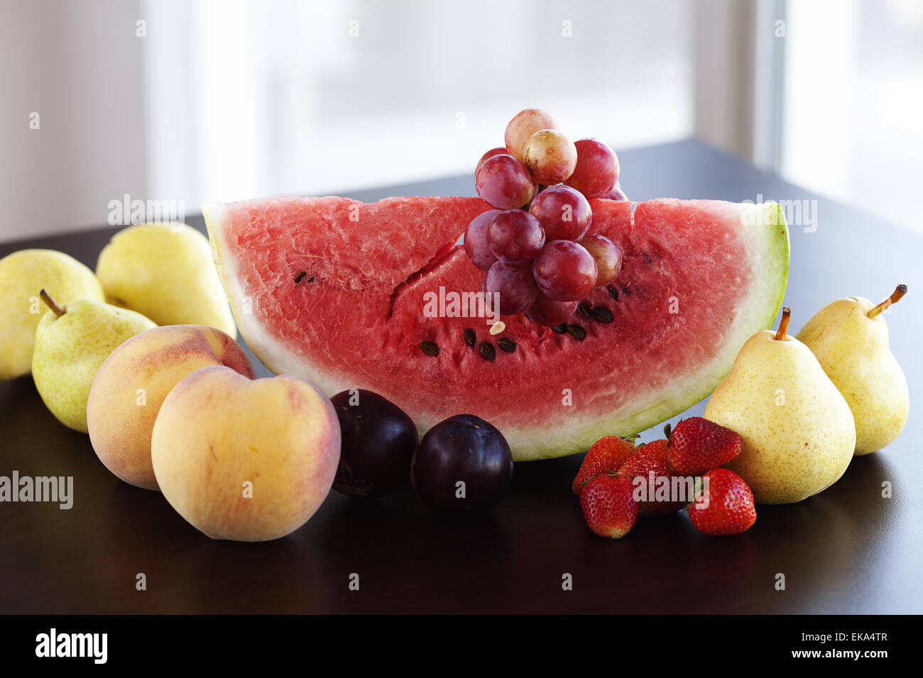 watermelon, strawberry, grape, plum and pear lying on a wooden t Stock ...