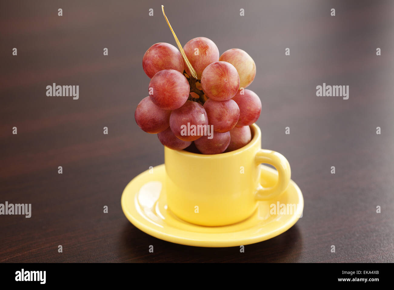 grapes in a cup and saucer on a wooden table Stock Photo - Alamy