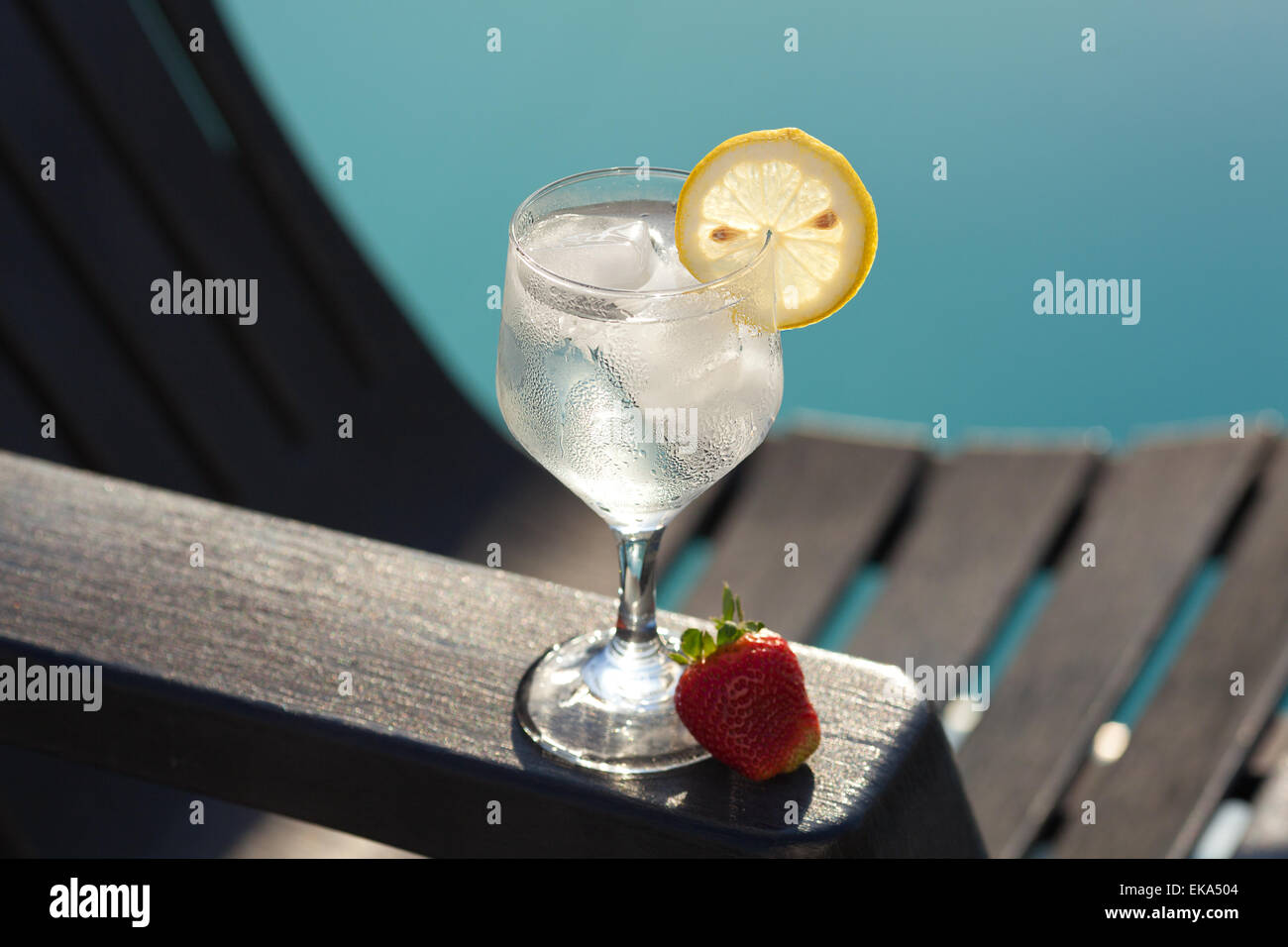 Swimming pool, lounge, a wine glass with ice, lemon and strawber Stock ...