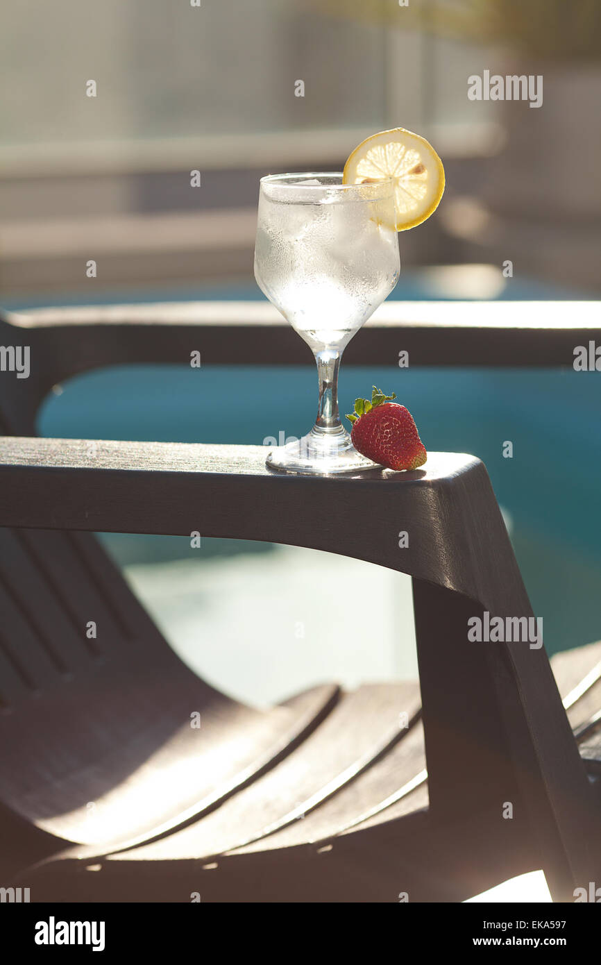 Swimming pool, lounge, a wine glass with ice, lemon and strawber Stock ...