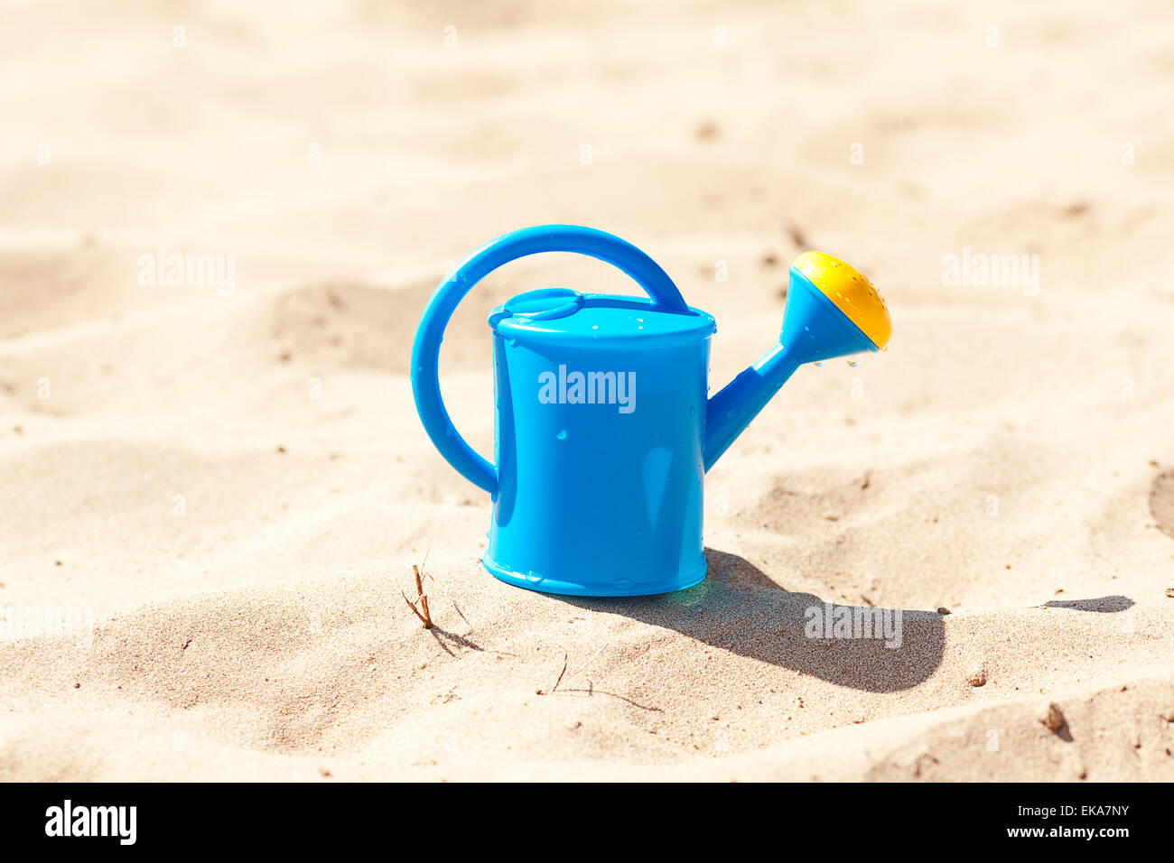 watering can on a background of sand Stock Photo - Alamy