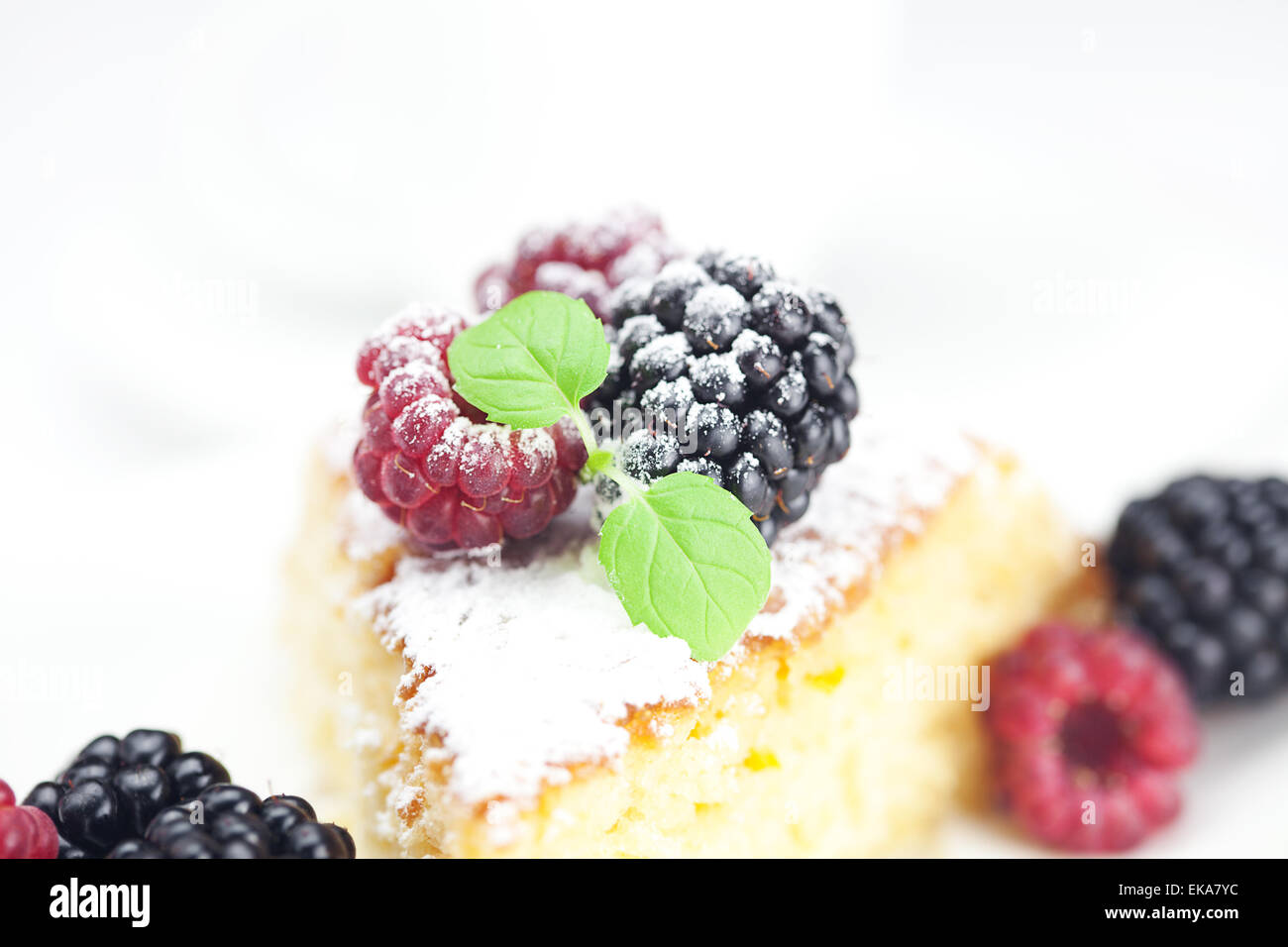 cake with icing, raspberry, blackberry and mint on a white back Stock ...