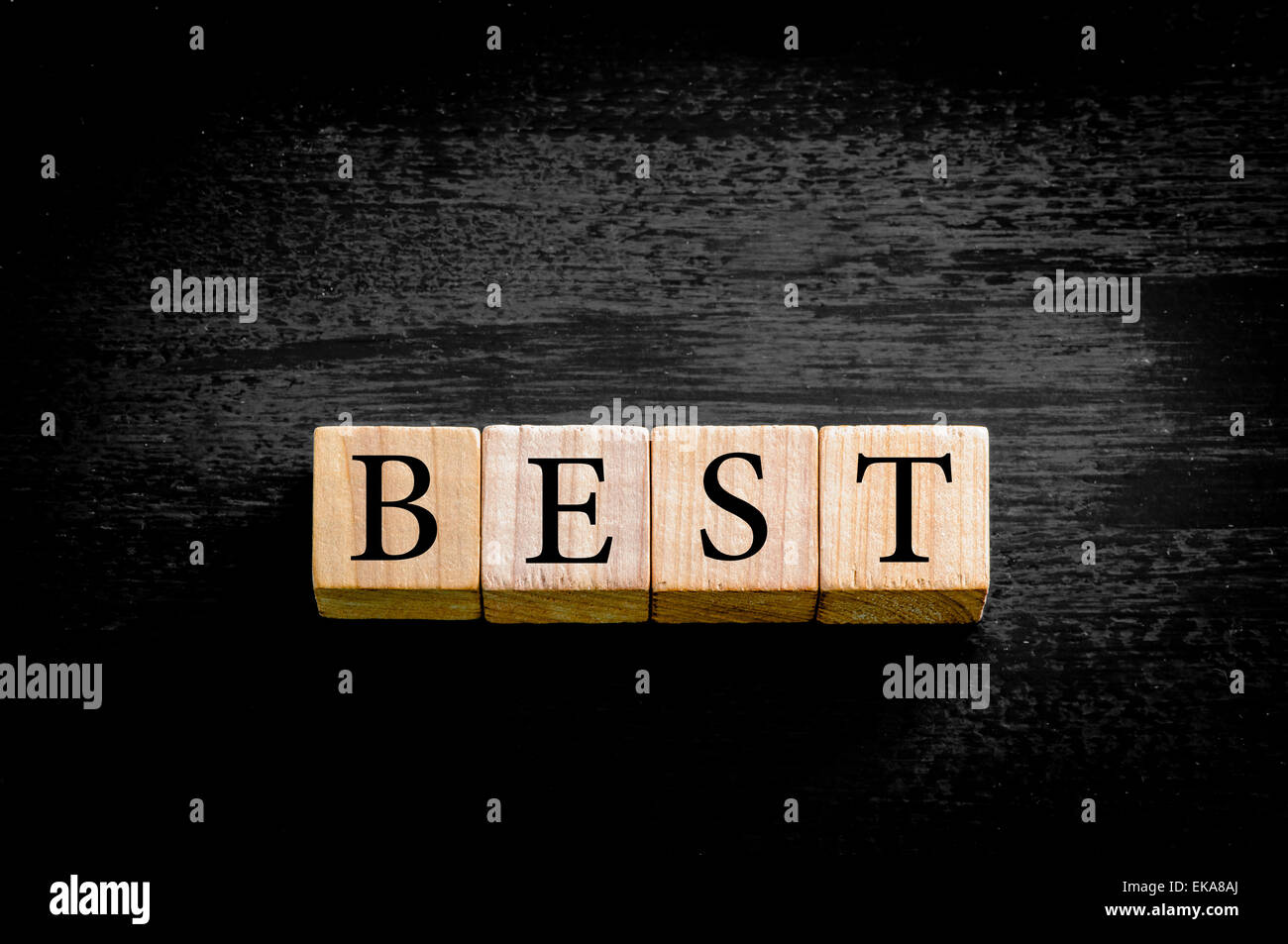 Word BEST. Wooden small cubes with letters isolated on black background ...