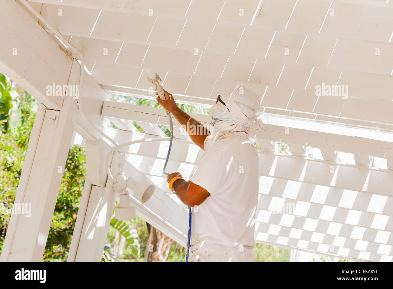 House Painter Wearing Facial Protection Spray Painting A Deck of A Home ...