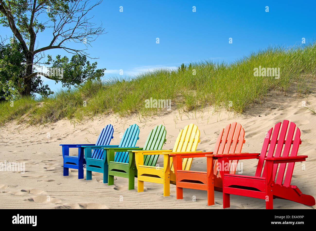 Row of colorful beach chairs in sand Stock Photo - Alamy