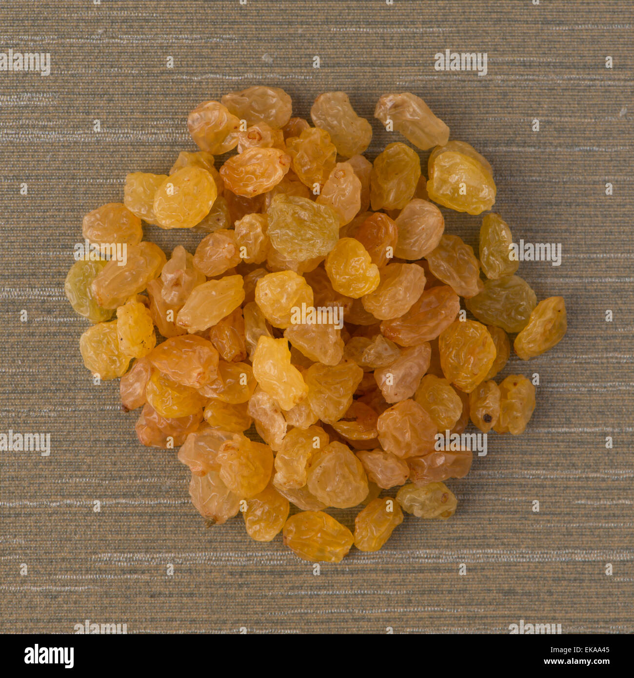 Top view of circle of golden raisins against green vinyl background ...