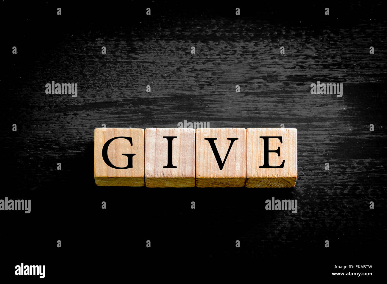 Word GIVE. Wooden small cubes with letters isolated on black background ...
