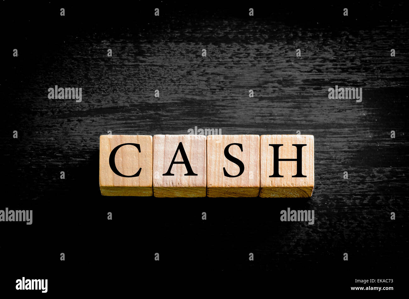 Word CASH. Wooden small cubes with letters isolated on black background ...