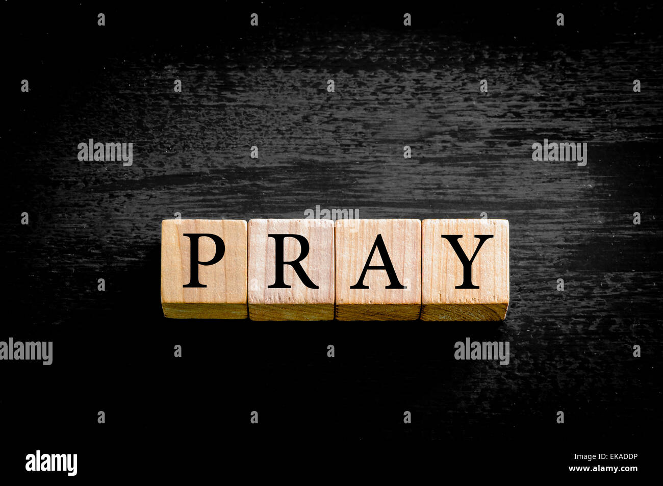 Word PRAY. Wooden small cubes with letters isolated on black background ...