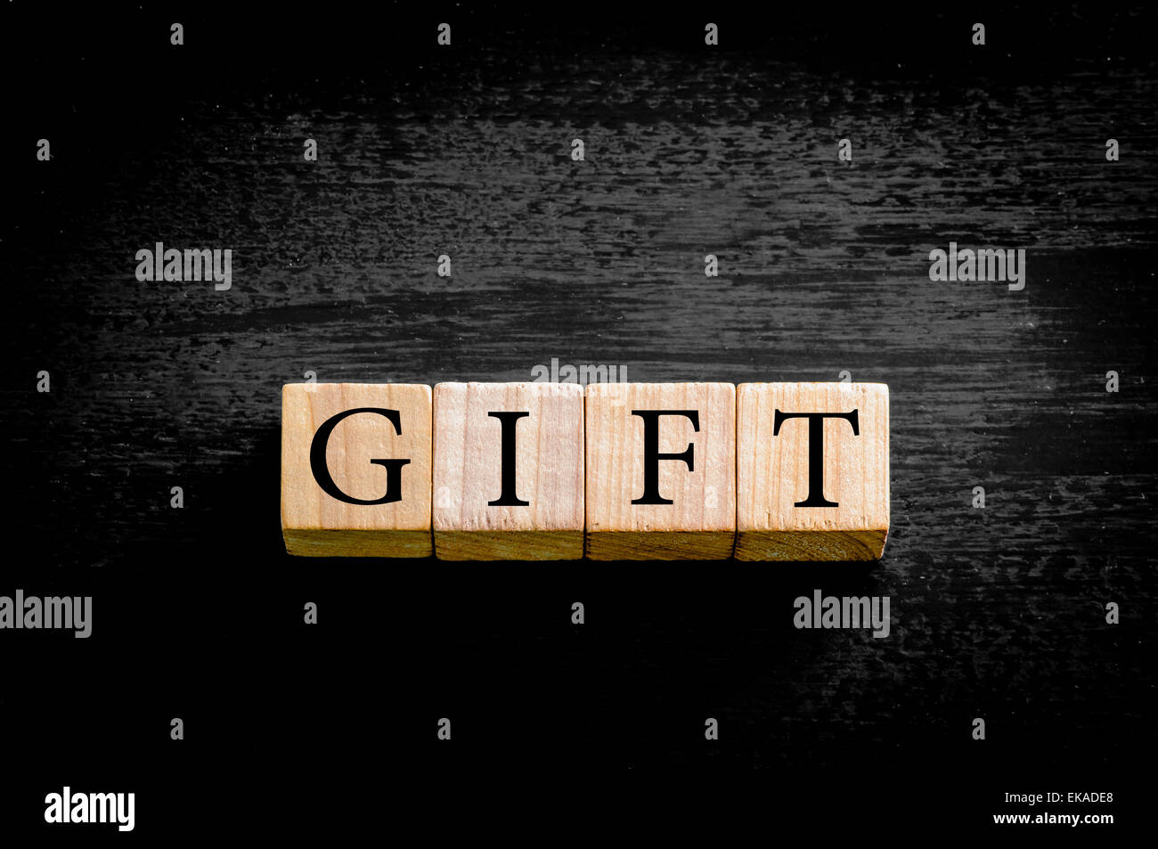 Word GIFT. Wooden small cubes with letters isolated on black background ...