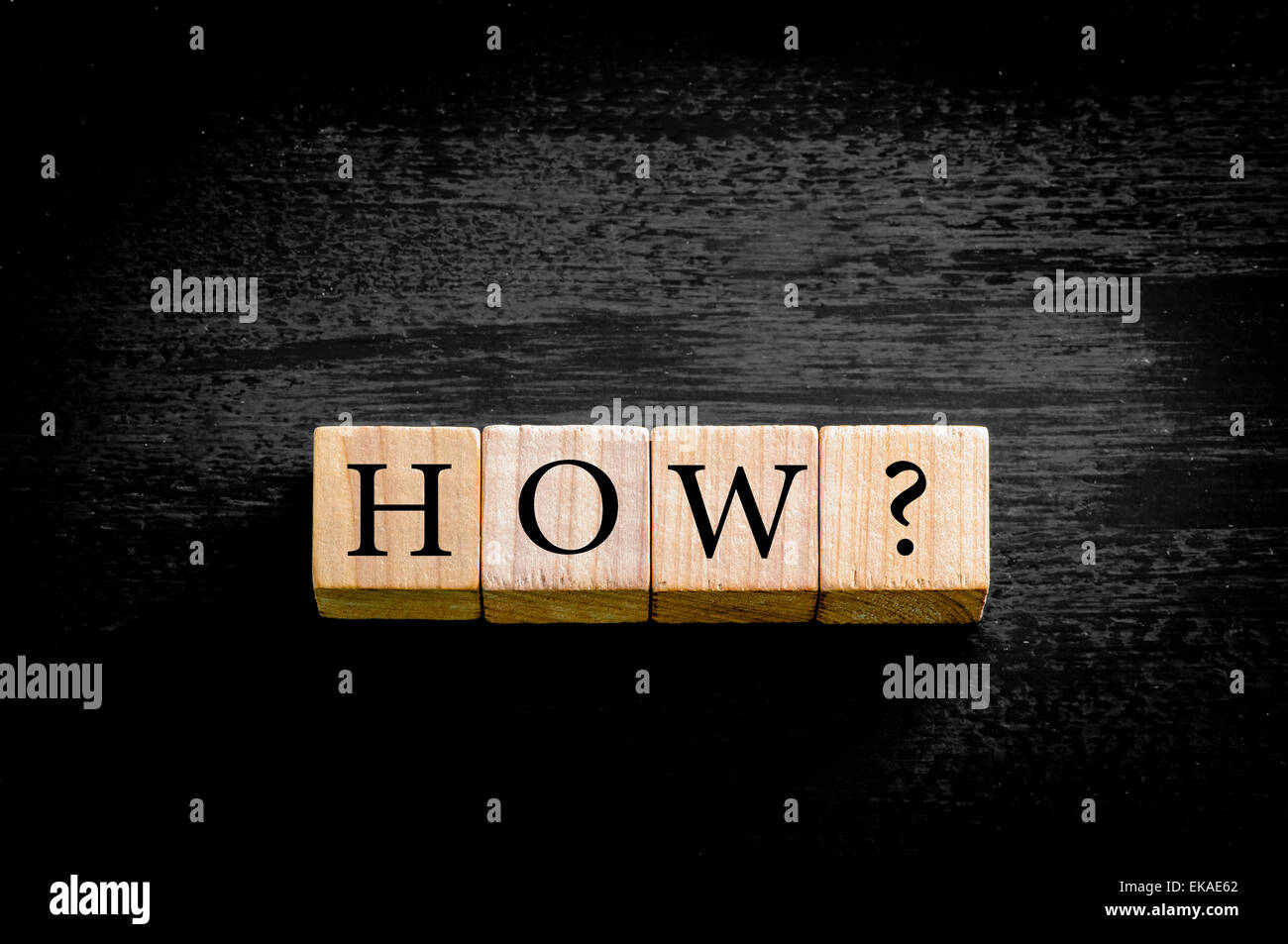 Word HOW. Wooden small cubes with letters isolated on black background ...